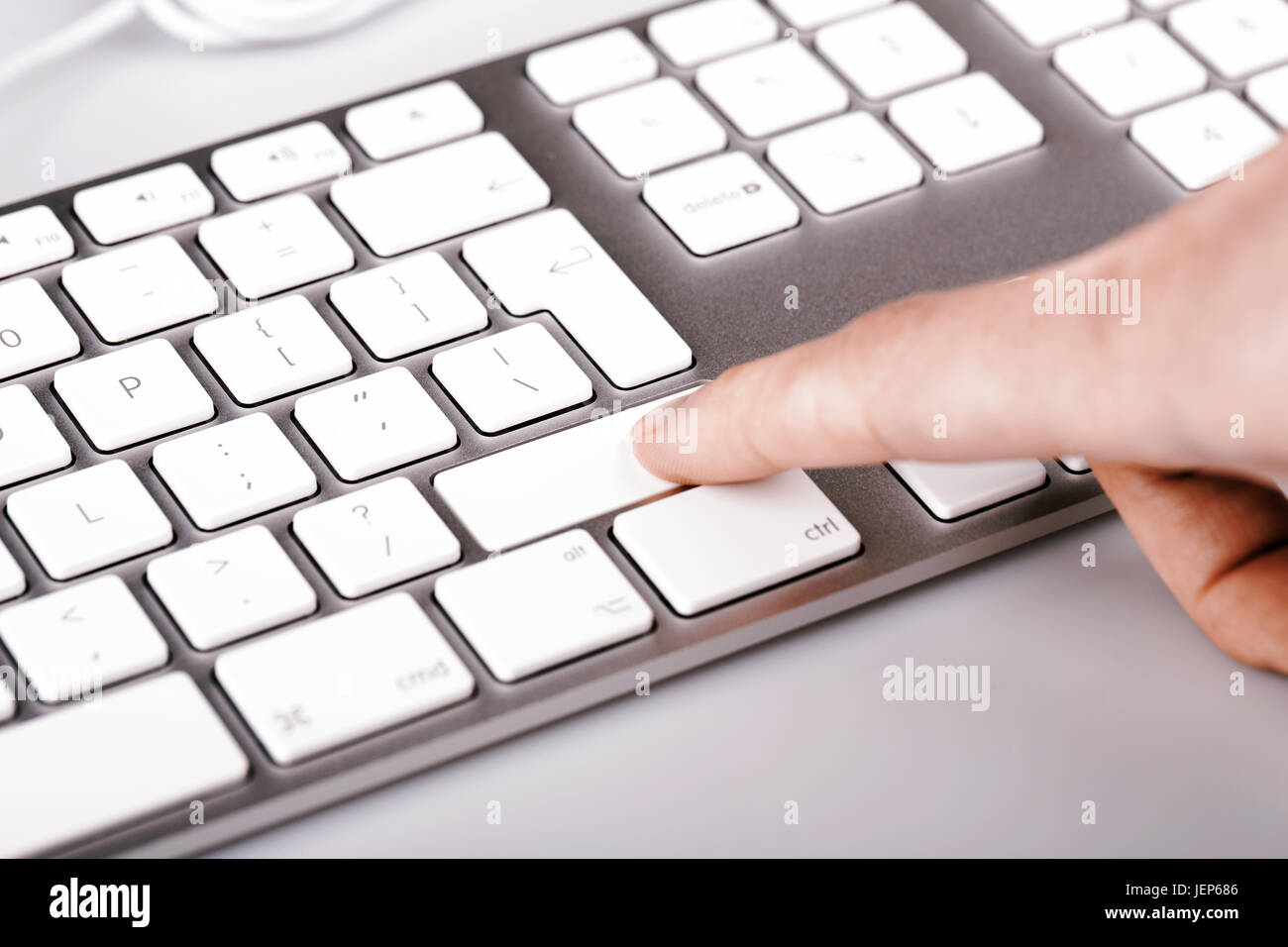 silver computer keyboard with white keys and woman finger and hand ...