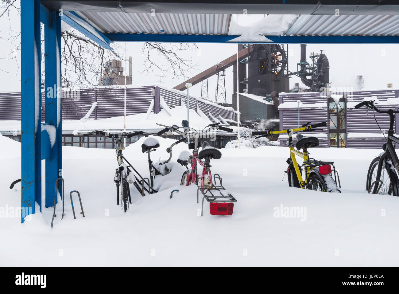 Bicycles in snow, factory buildings on background Stock Photo - Alamy
