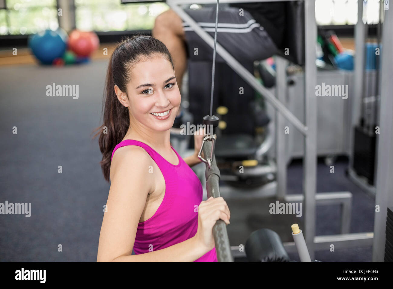 Fit woman using weight machine Stock Photo - Alamy