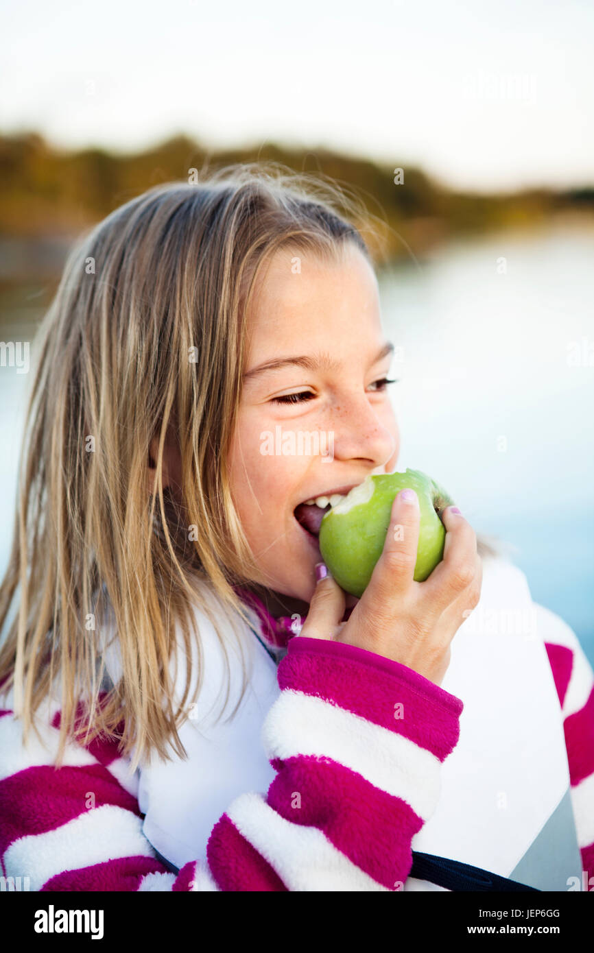 Smiling girl eating apple Stock Photo - Alamy