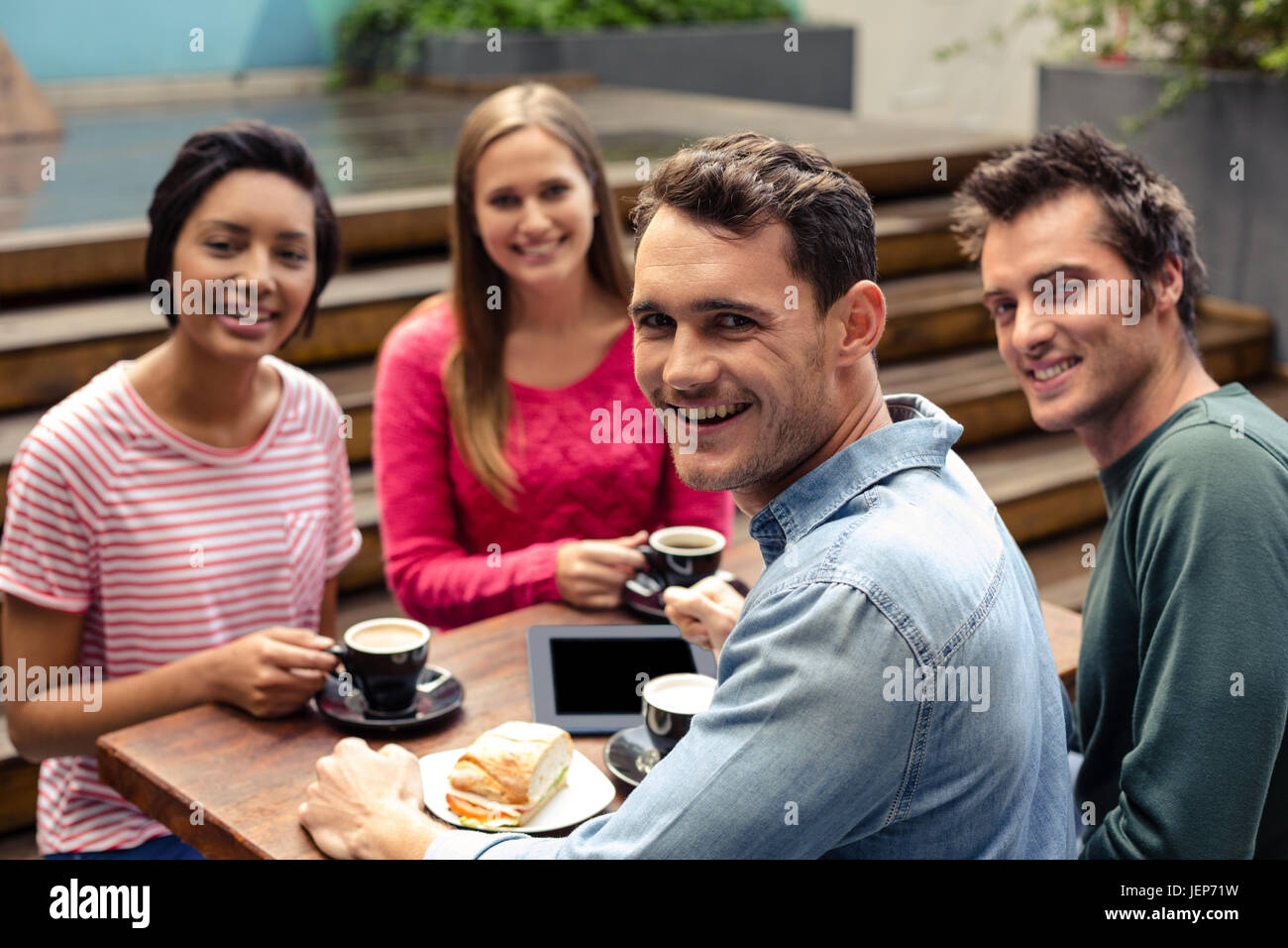 Happy friends having coffee together Stock Photo - Alamy