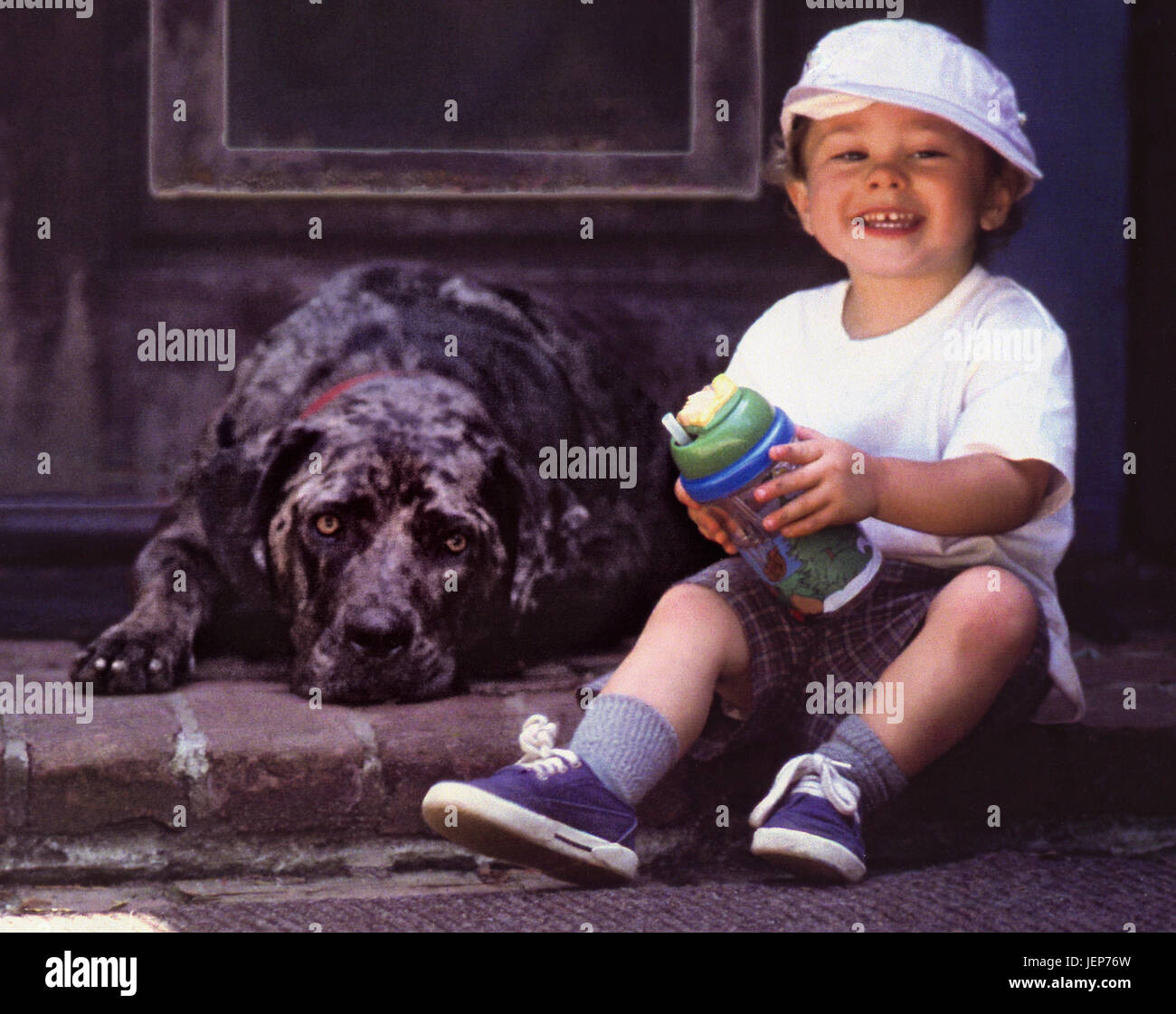 Smiling Toddler with sad looking dog Stock Photo - Alamy