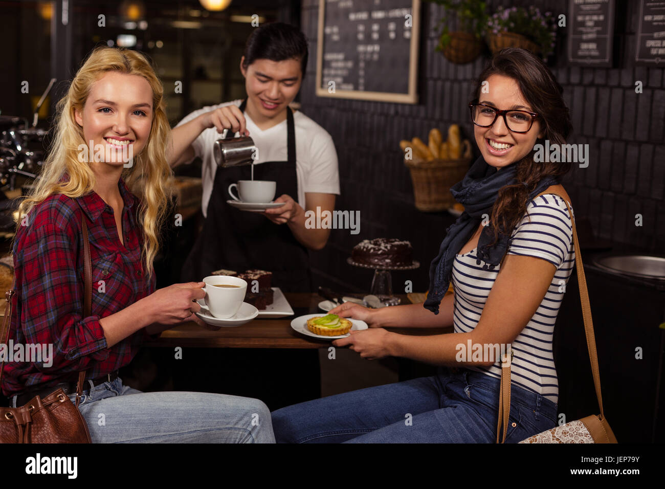 Smiling friends enjoying pastries Stock Photo - Alamy