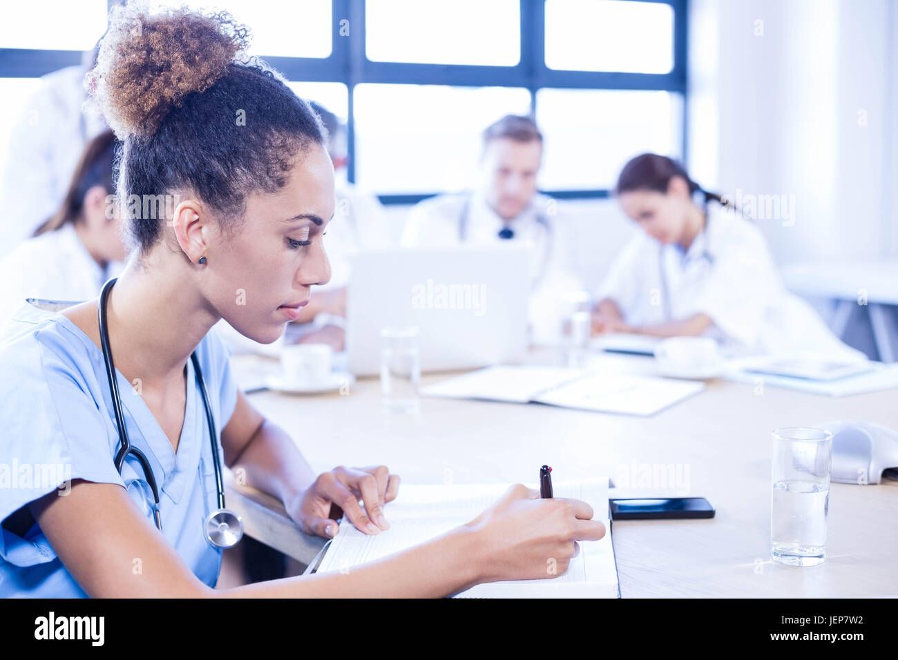 Female doctors writing on clipboard Stock Photo - Alamy