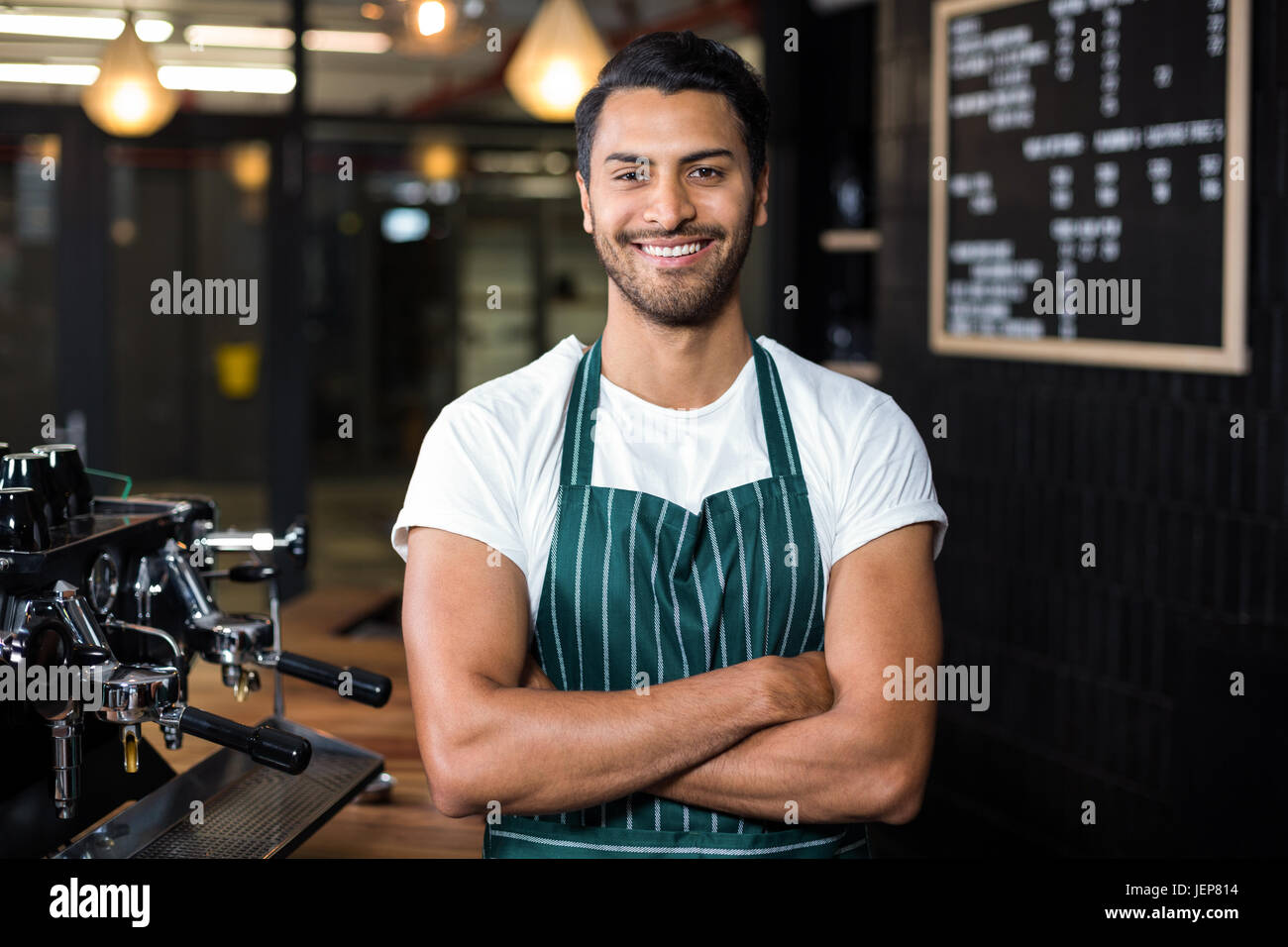 Smiling barista standing with arms crossed Stock Photo - Alamy