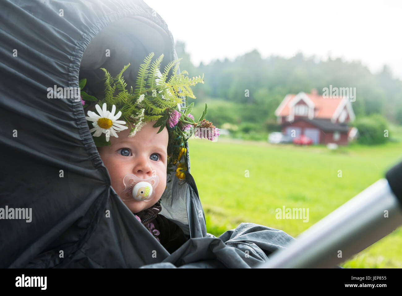 Baby in buggy wearing flower wreath Stock Photo - Alamy