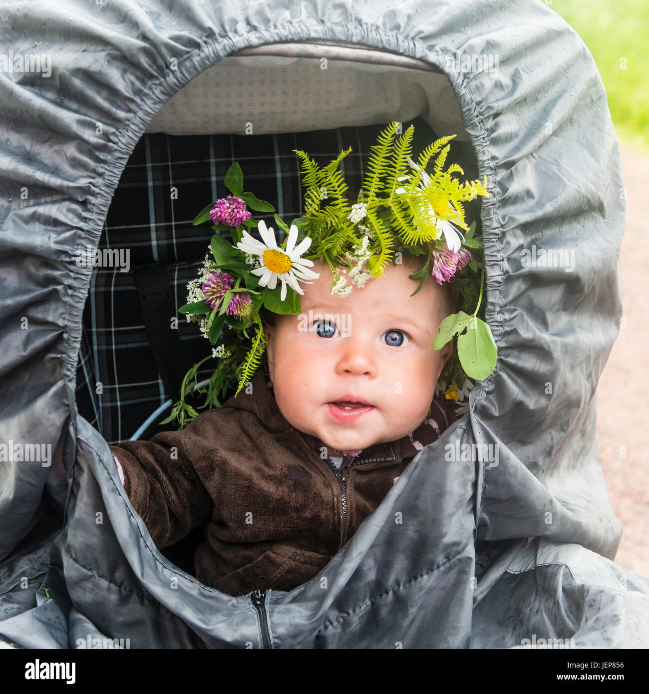 Baby in buggy wearing flower wreath Stock Photo - Alamy