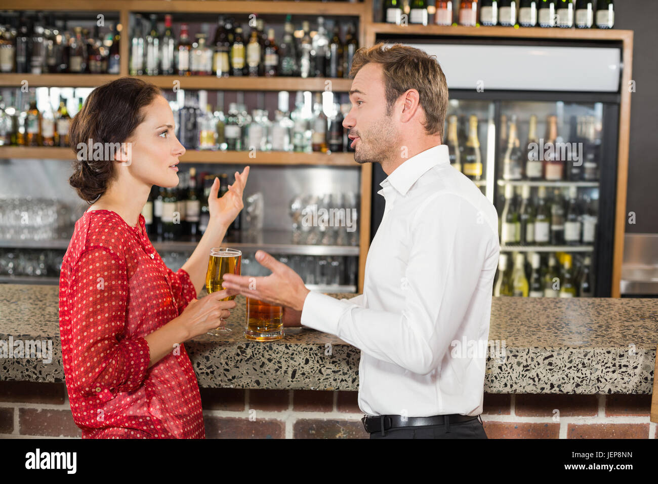Couple arguing and holding beer Stock Photo - Alamy