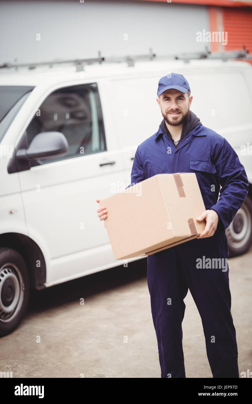 Delivery man holding box Stock Photo - Alamy