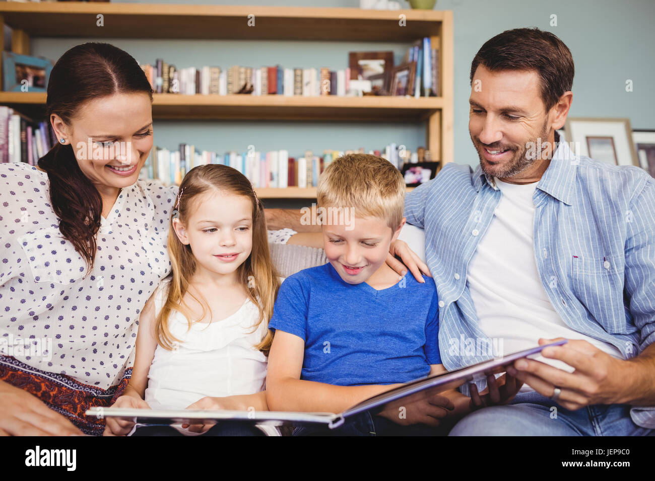 Cheerful family reading book Stock Photo - Alamy