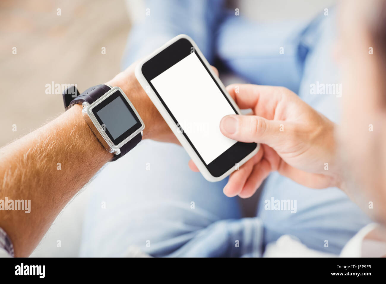 Man wearing smart watch and using smartphone Stock Photo - Alamy