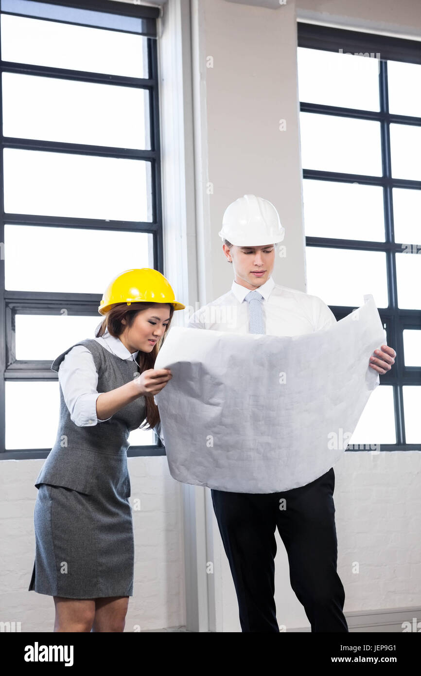 Architects looking at blueprint Stock Photo - Alamy