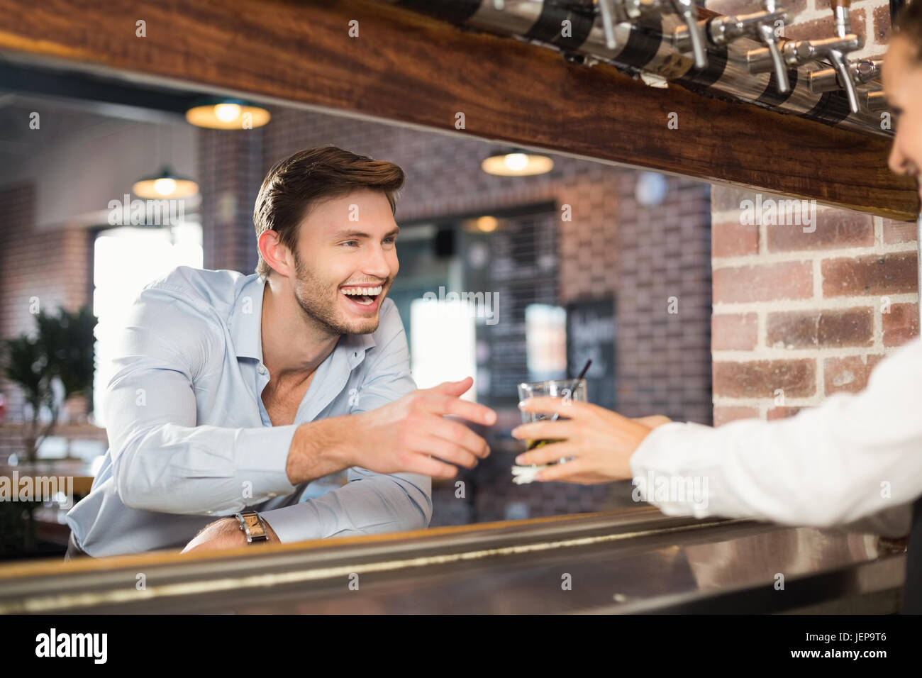 Man getting his order from barmaid Stock Photo - Alamy