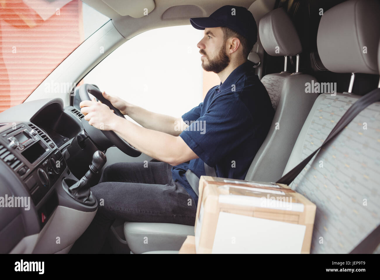 Delivery man driving his van Stock Photo - Alamy