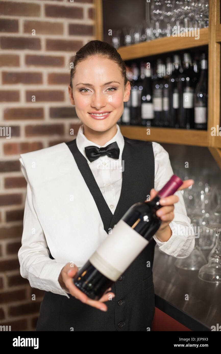 Barmaid holding a wine bottle Stock Photo - Alamy