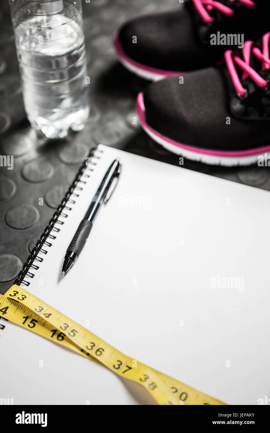 Notepad, measuring tape, shoes and bottle Stock Photo - Alamy