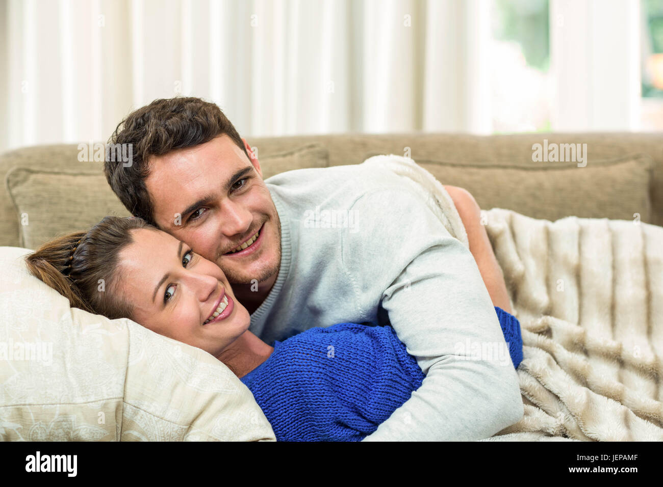 Couple cuddling up on sofa hi-res stock photography and images - Alamy