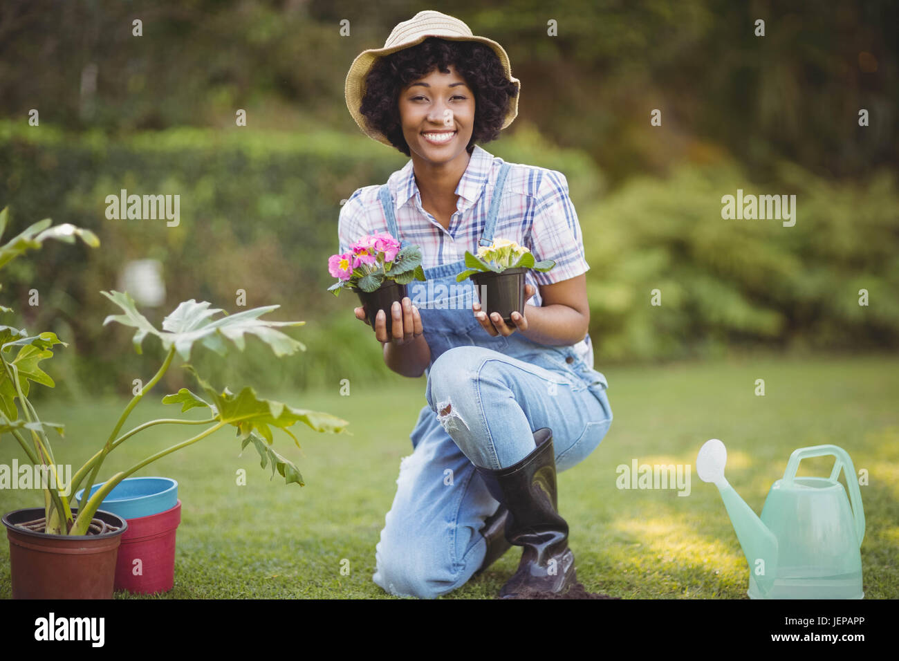 Smiling woman crouching in the garden Stock Photo - Alamy