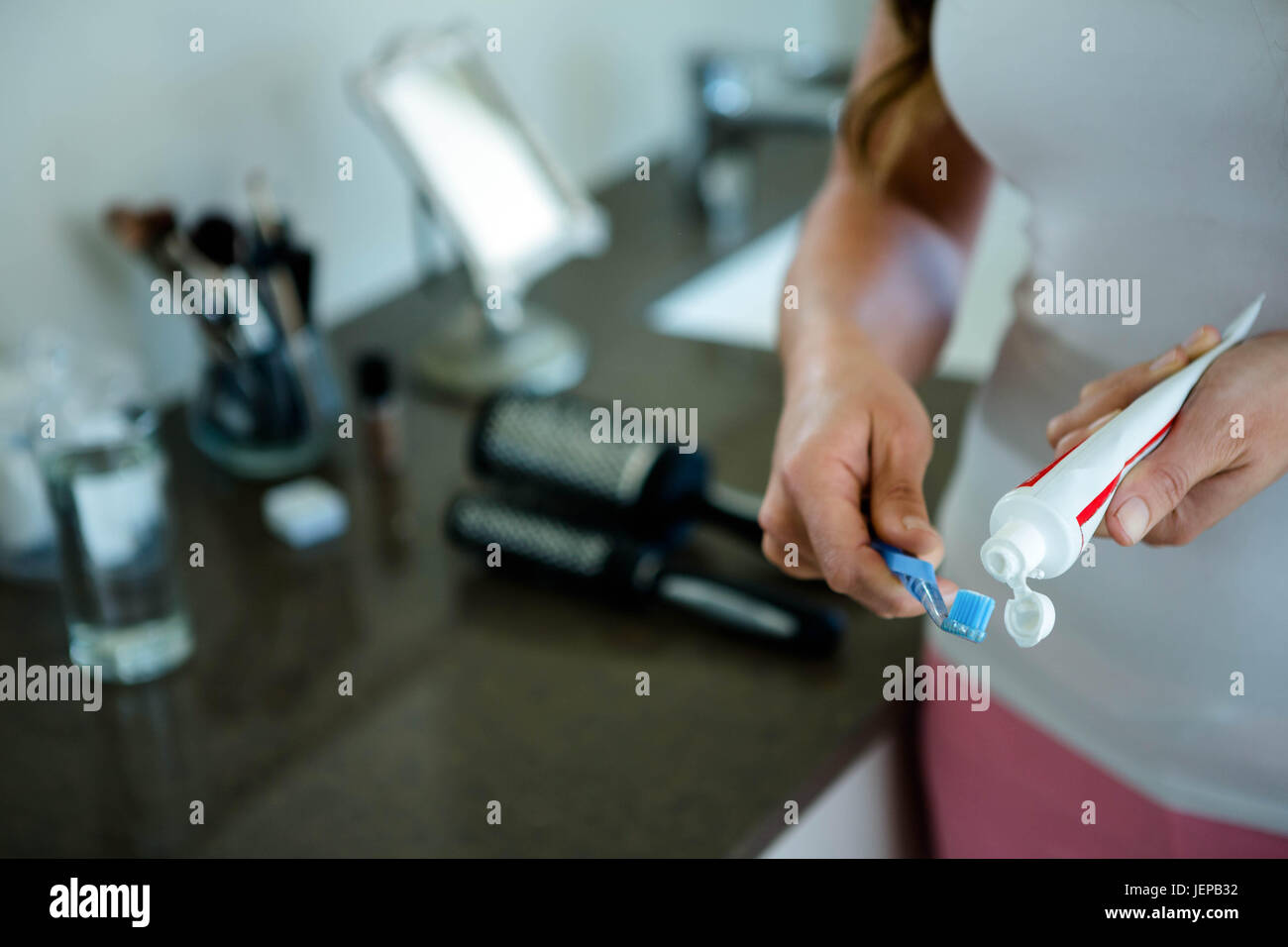 woman squeezing toothpaste onto toothbrush Stock Photo - Alamy