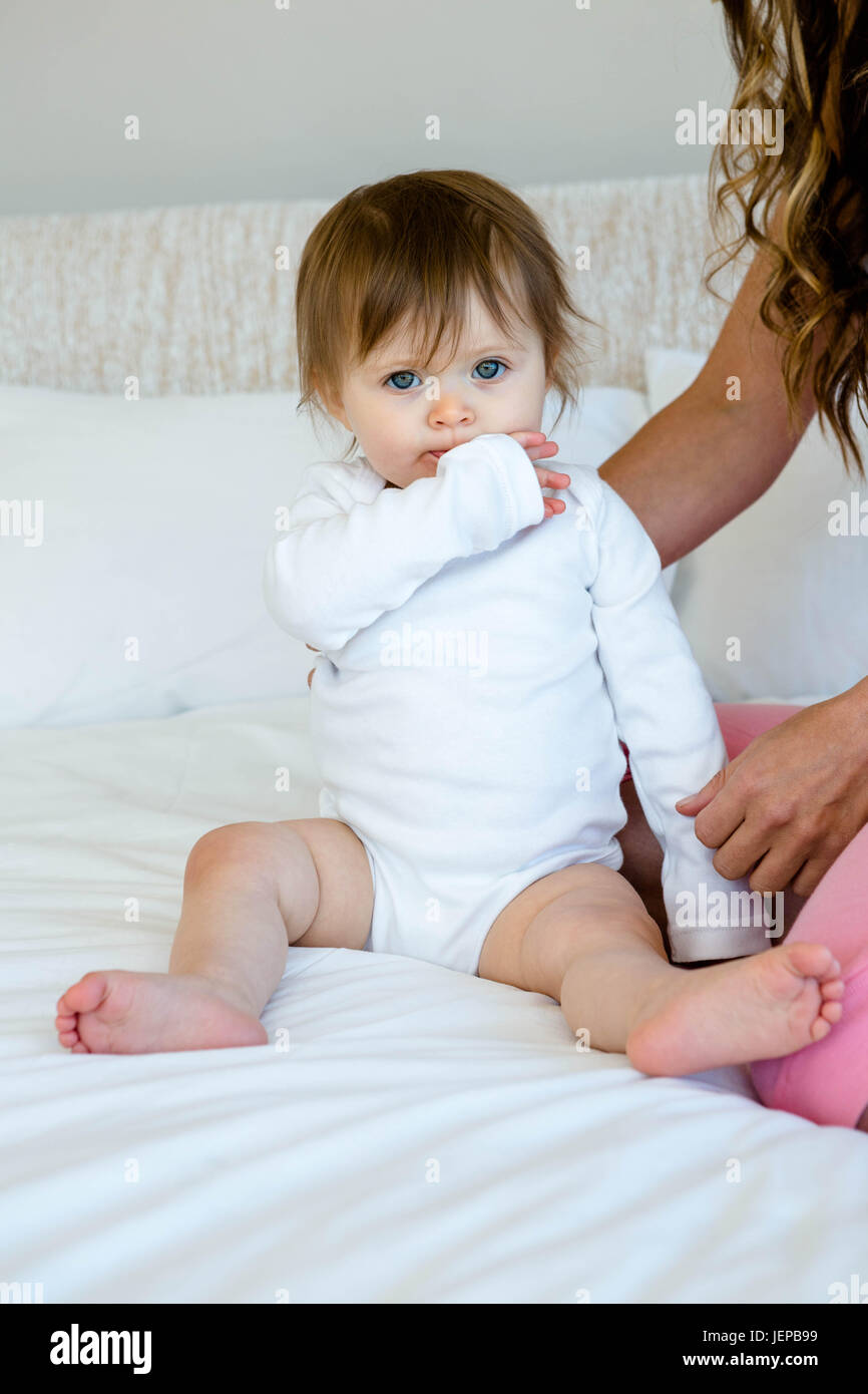 adorable baby chewing on her sleeve Stock Photo - Alamy