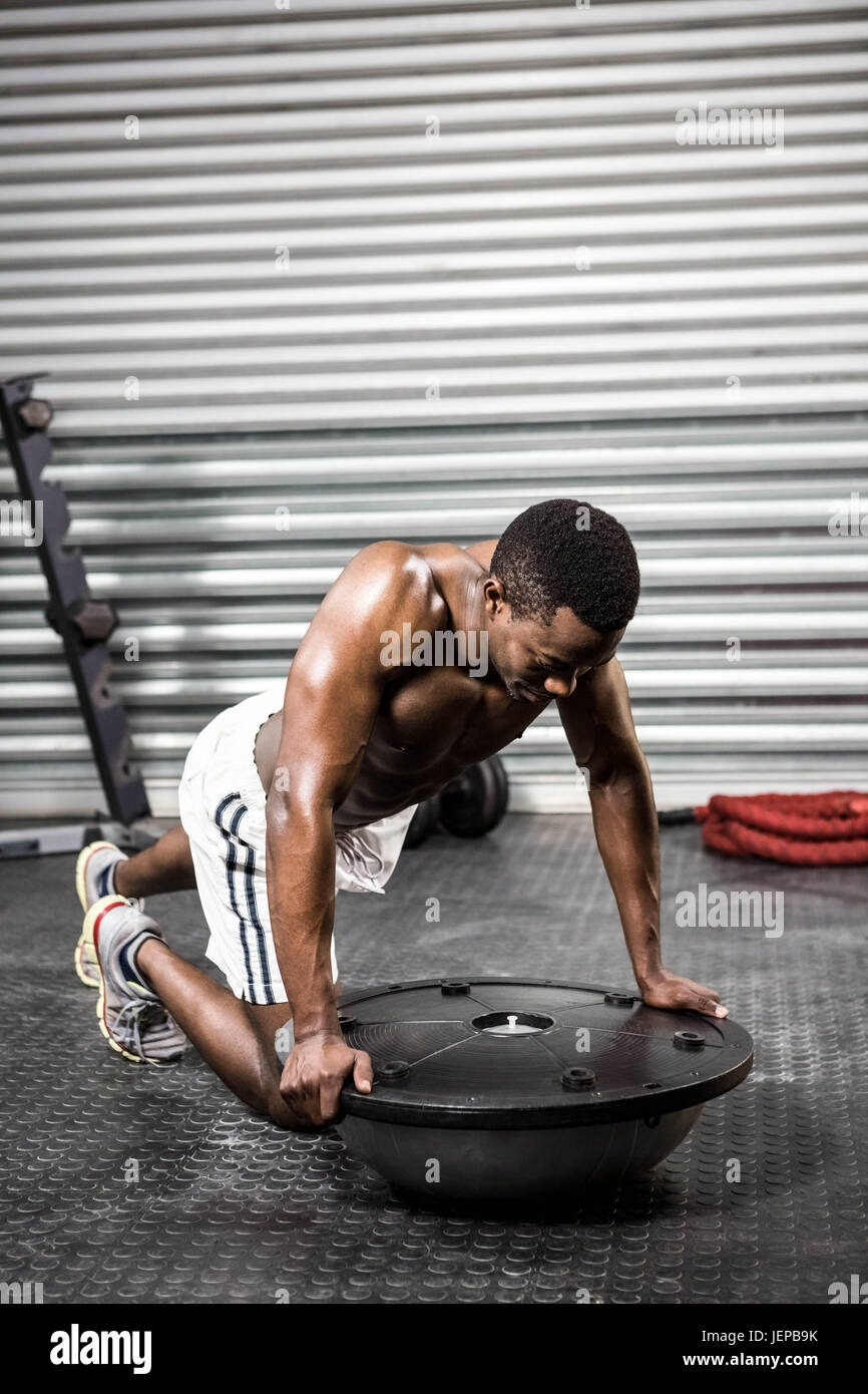 Muscular man doing push up on bosu ball Stock Photo - Alamy