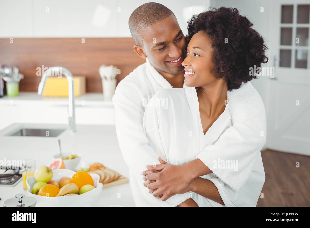 Happy couple hugging in the kitchen Stock Photo - Alamy