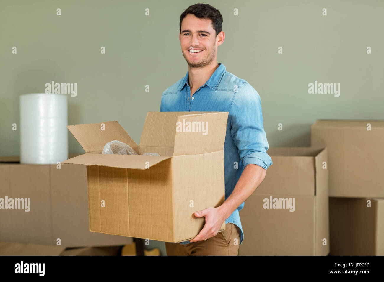 Young man carrying carton boxes Stock Photo - Alamy