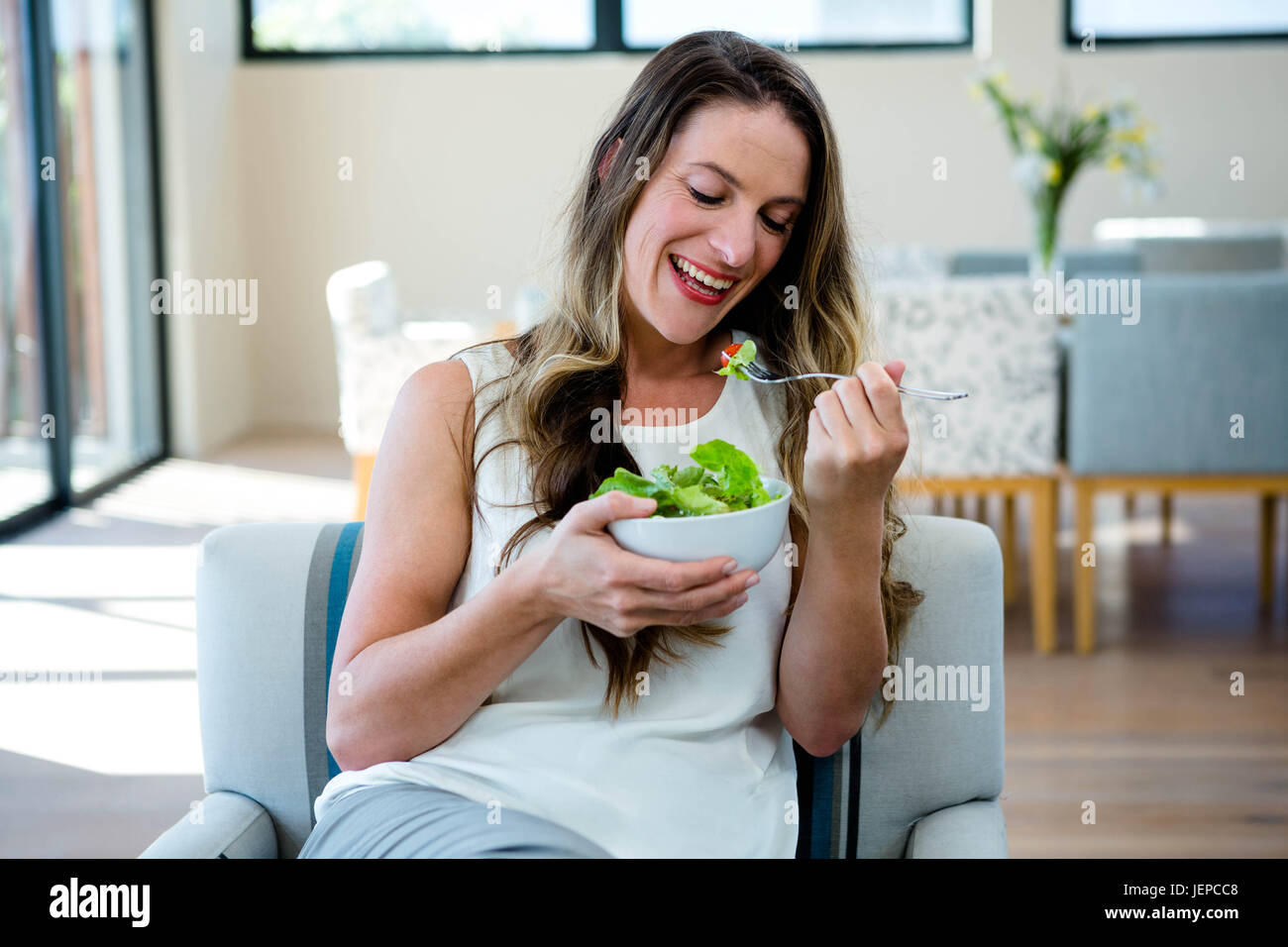 smiling woman eating a salad Stock Photo - Alamy