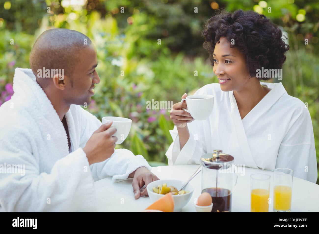 Happy couple taking breakfast in the garden Stock Photo - Alamy