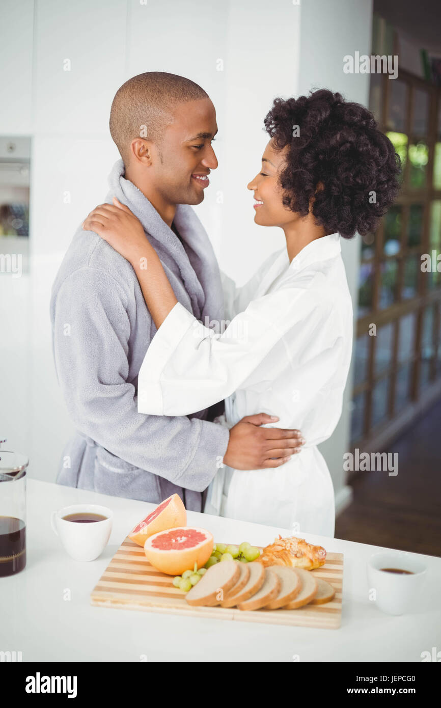 Happy couple hugging in the kitchen Stock Photo - Alamy