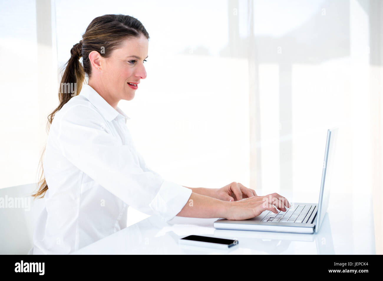 smiling business woman typing on her laptop Stock Photo - Alamy