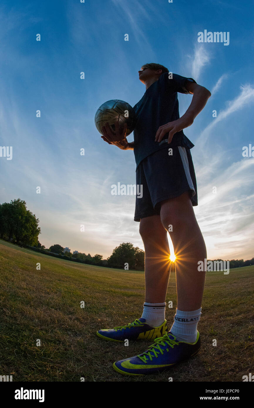a young boy playing football and practicing his football skills and ...