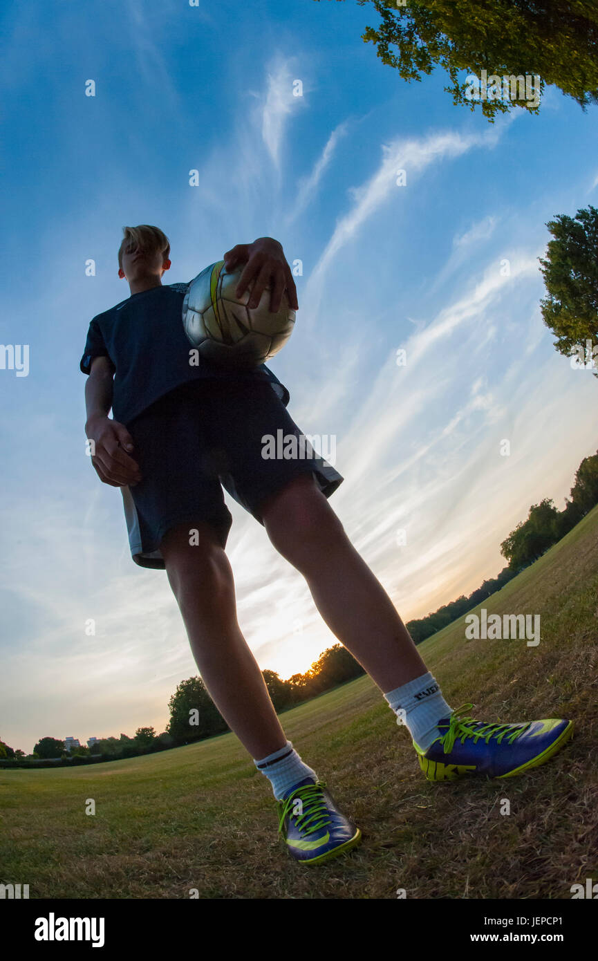 a young boy playing football and practicing his football skills and ...