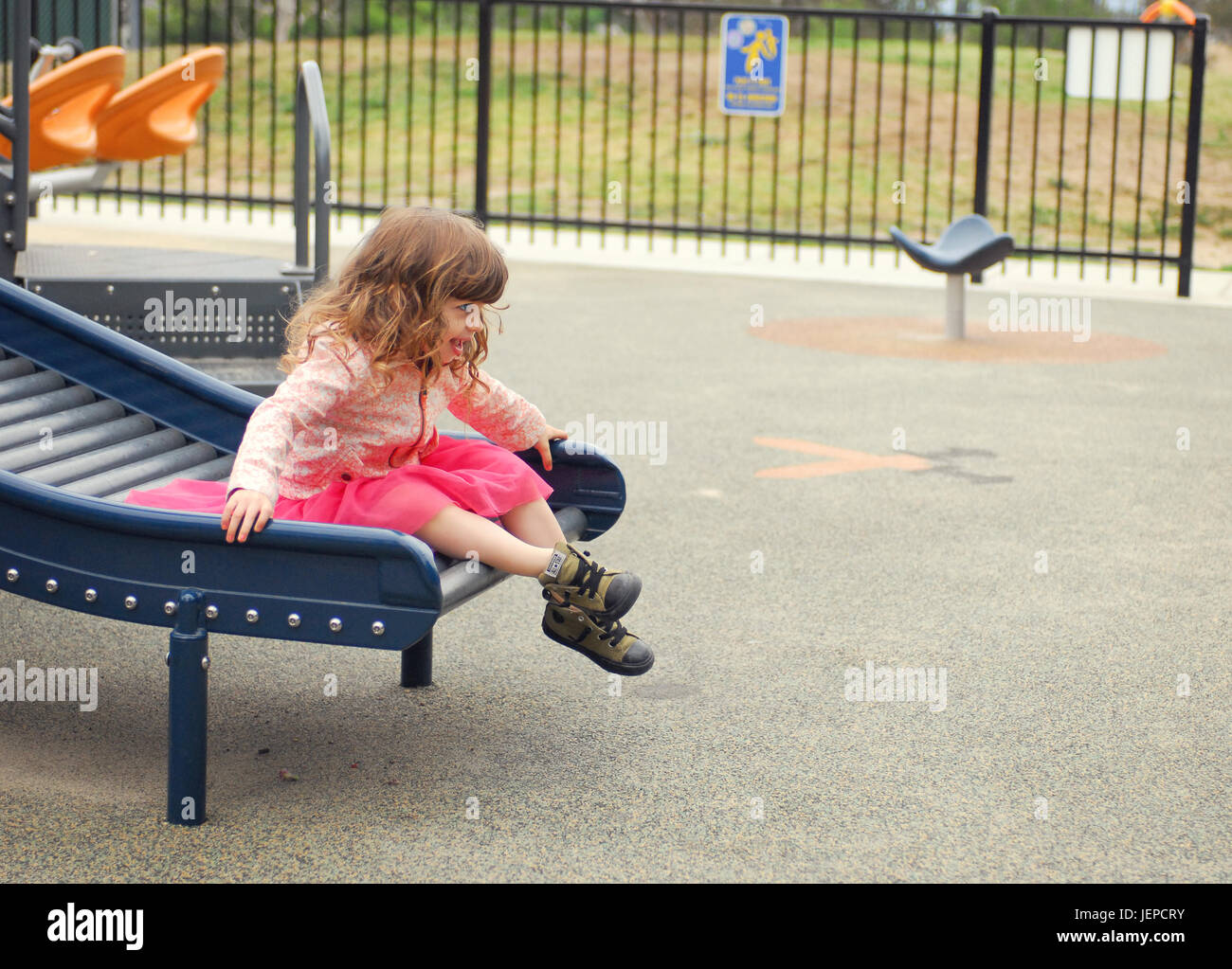 Happy kid sliding down roller slide at park Stock Photo - Alamy