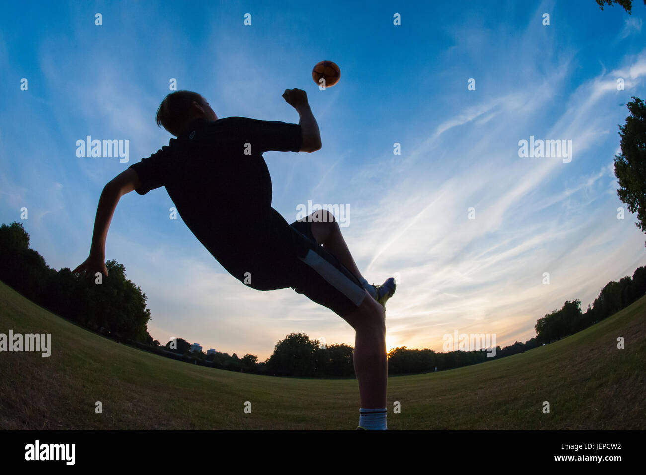 a young boy playing football and practicing his football skills and ...