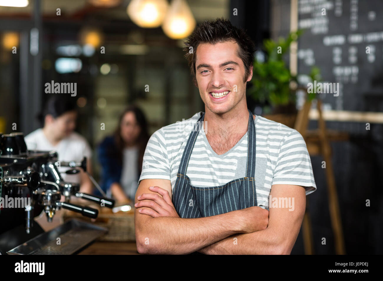 Smiling barista with arms crossed Stock Photo - Alamy