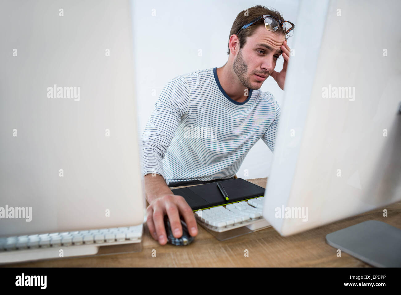 Tired man working on computer Stock Photo - Alamy