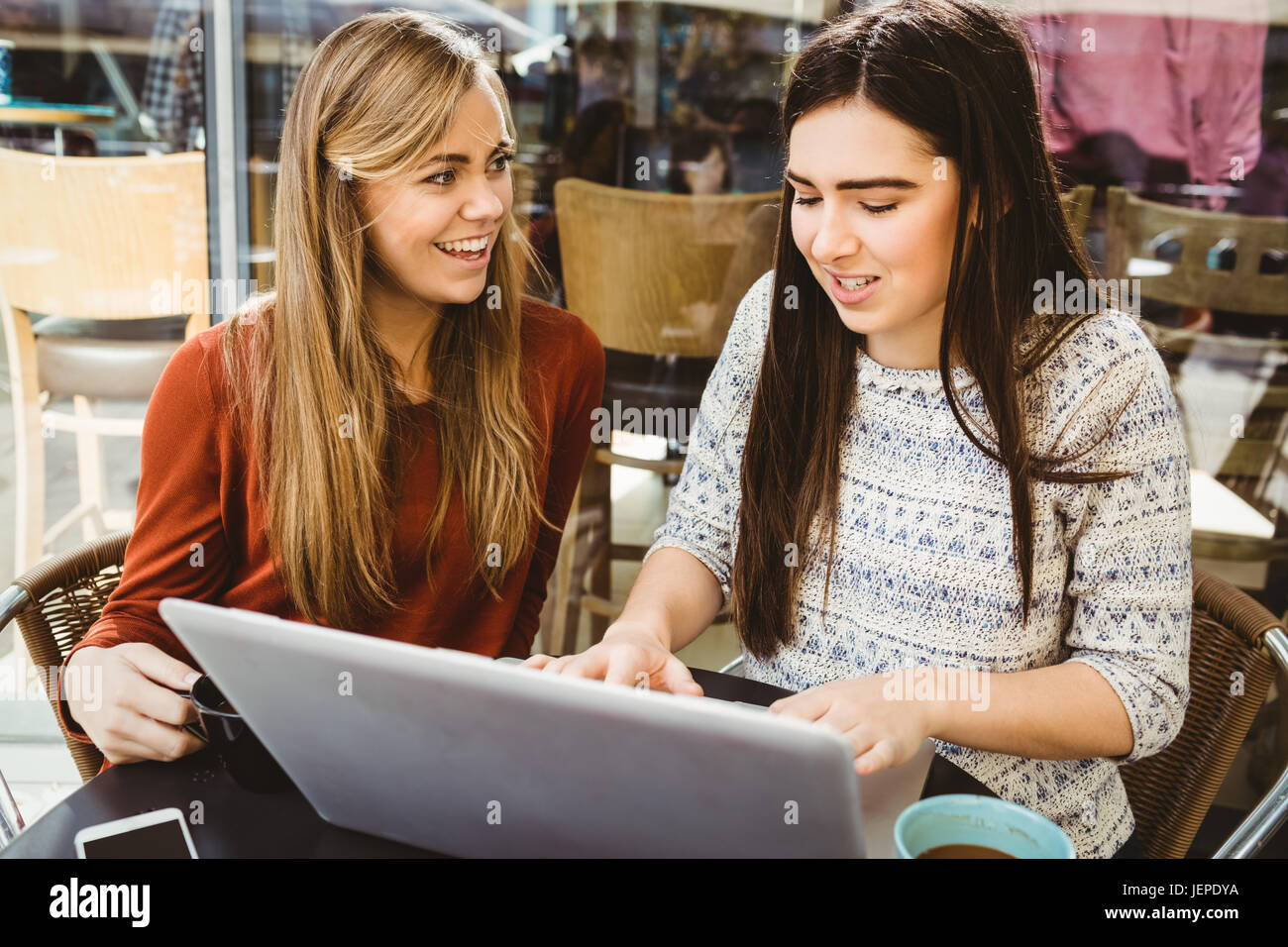 Friends using laptop together Stock Photo - Alamy