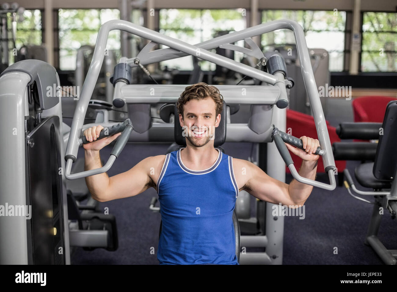 Fit man using weight machine Stock Photo - Alamy