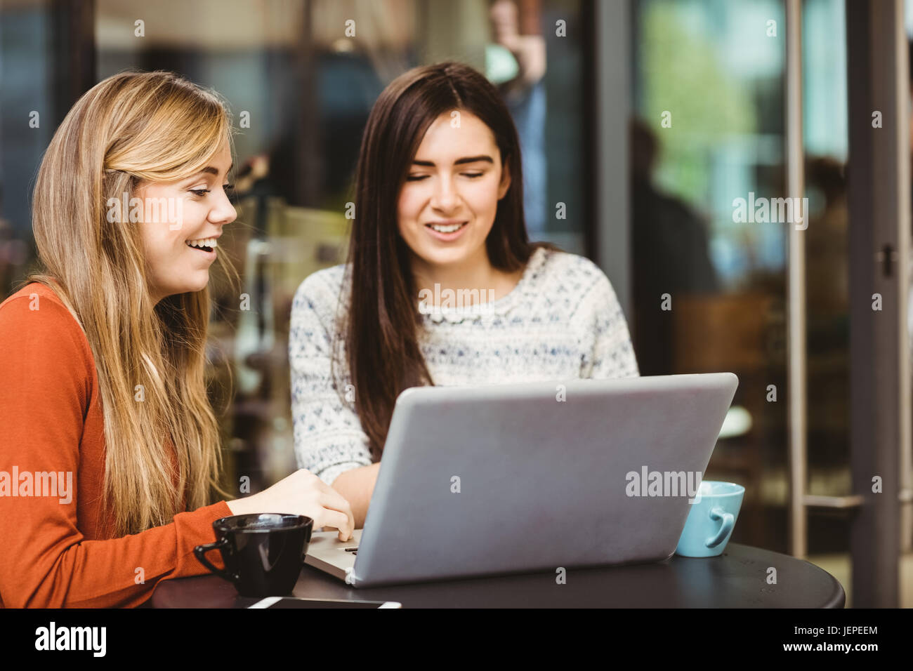 Friends using laptop together Stock Photo - Alamy