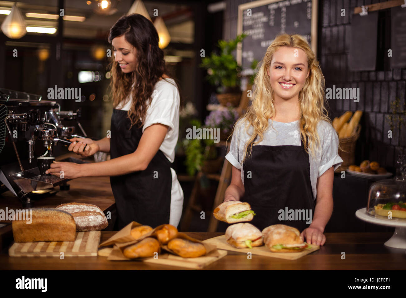 Pretty waitresses behind the counter working Stock Photo - Alamy