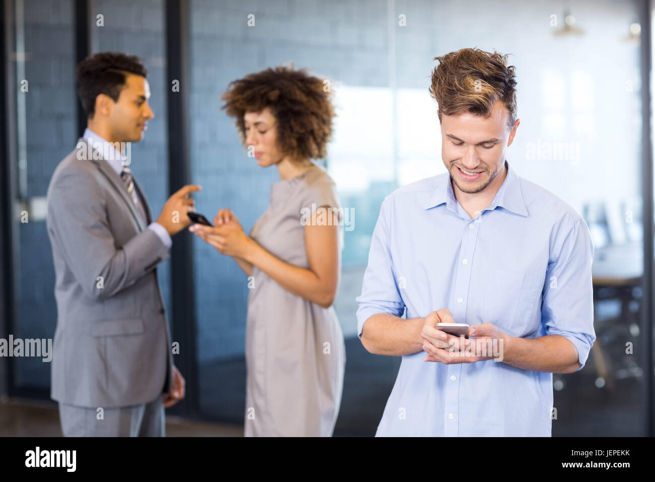 Confident executive using mobile phone Stock Photo - Alamy