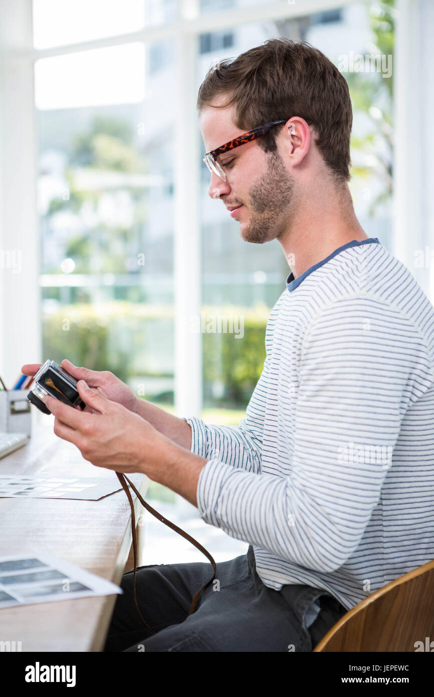 Handsome man looking at pictures on camera Stock Photo - Alamy