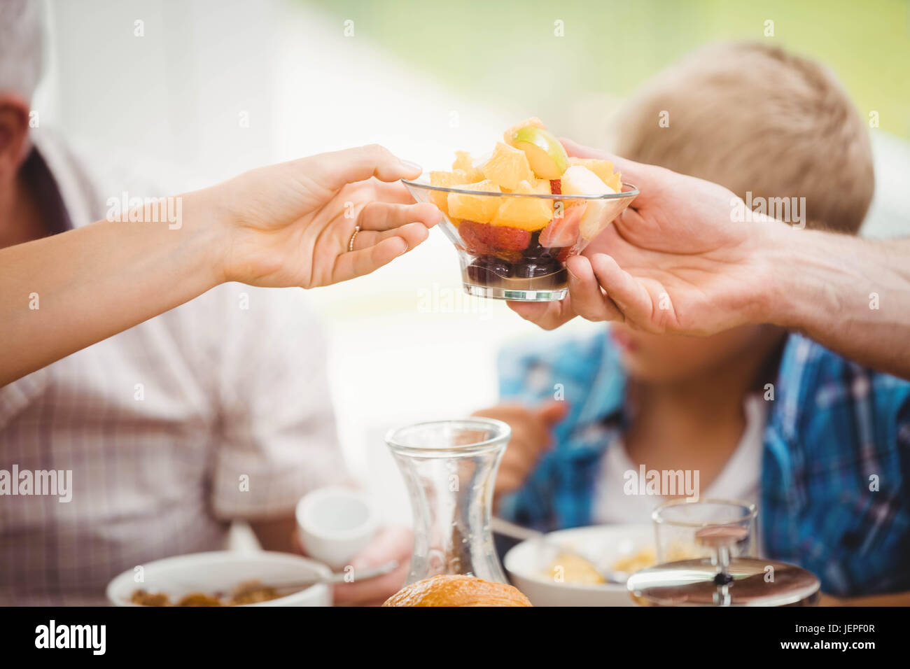 Close-up of hands passing bowl of fruits Stock Photo - Alamy