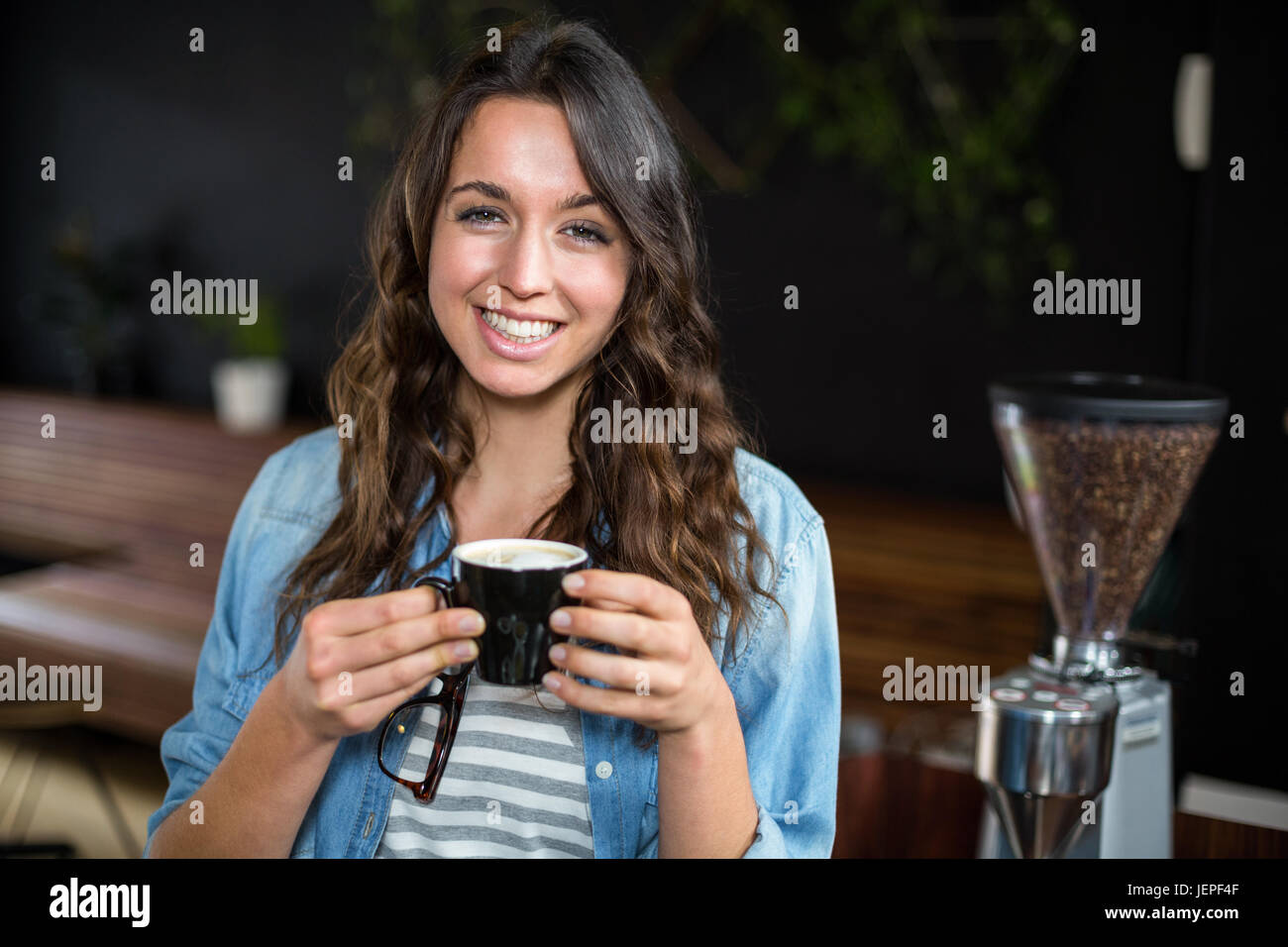 Smiling brunette drinking coffee Stock Photo - Alamy