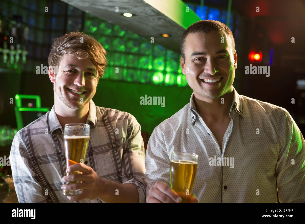 Portrait of two men having beer at bar Stock Photo - Alamy