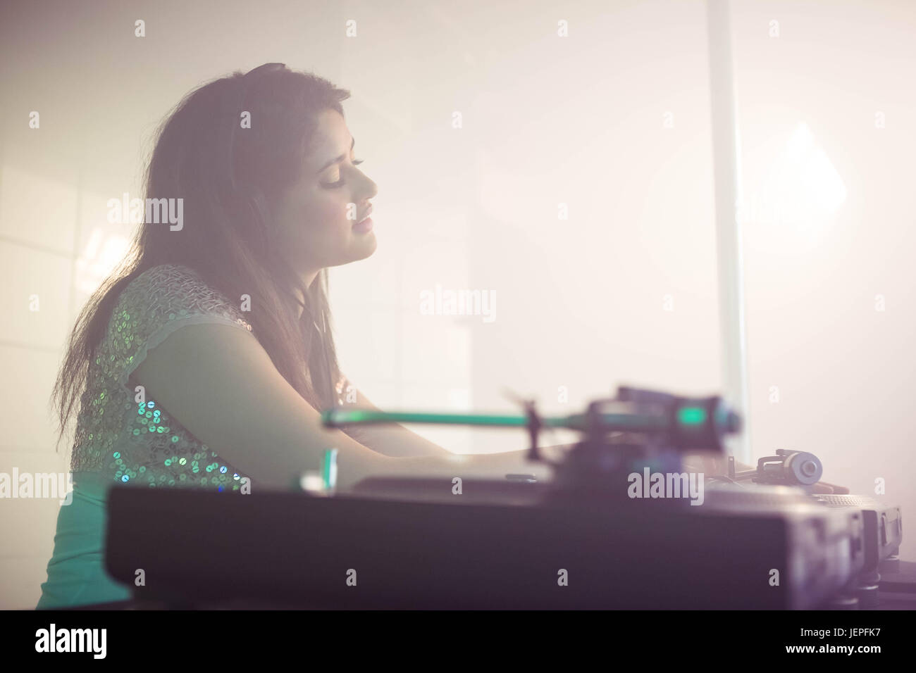 Pretty female DJ playing music Stock Photo - Alamy