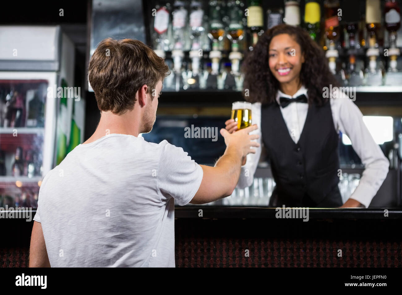 Barmaid serving beer to man Stock Photo - Alamy