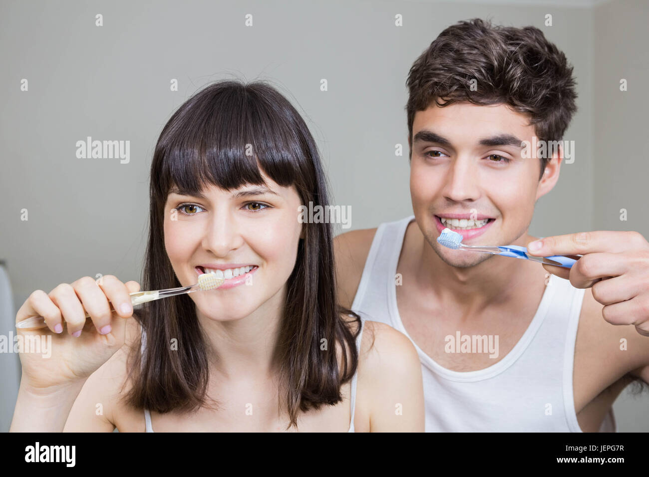 Young couple brushing their teeth Stock Photo - Alamy