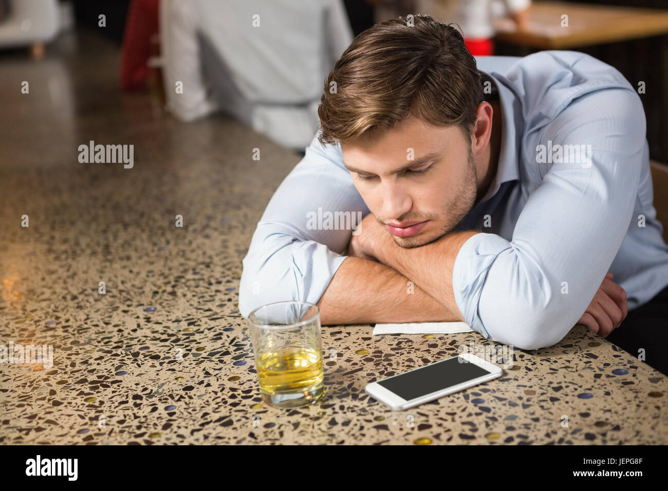 Tired man leaning on counter Stock Photo - Alamy